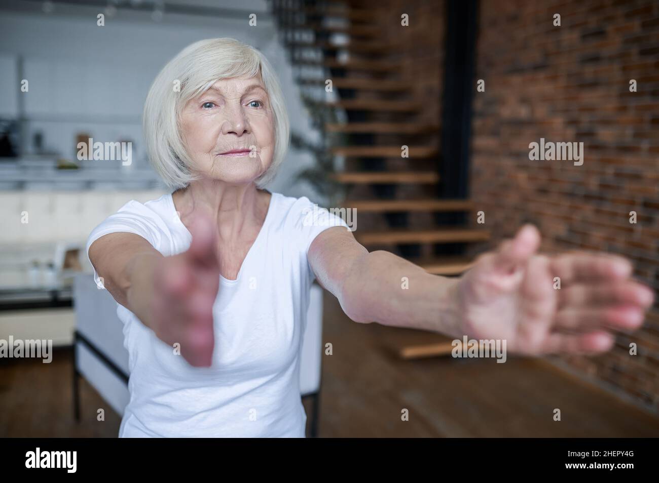 Gray-haired senior woman standing with her arms forward Stock Photo - Alamy