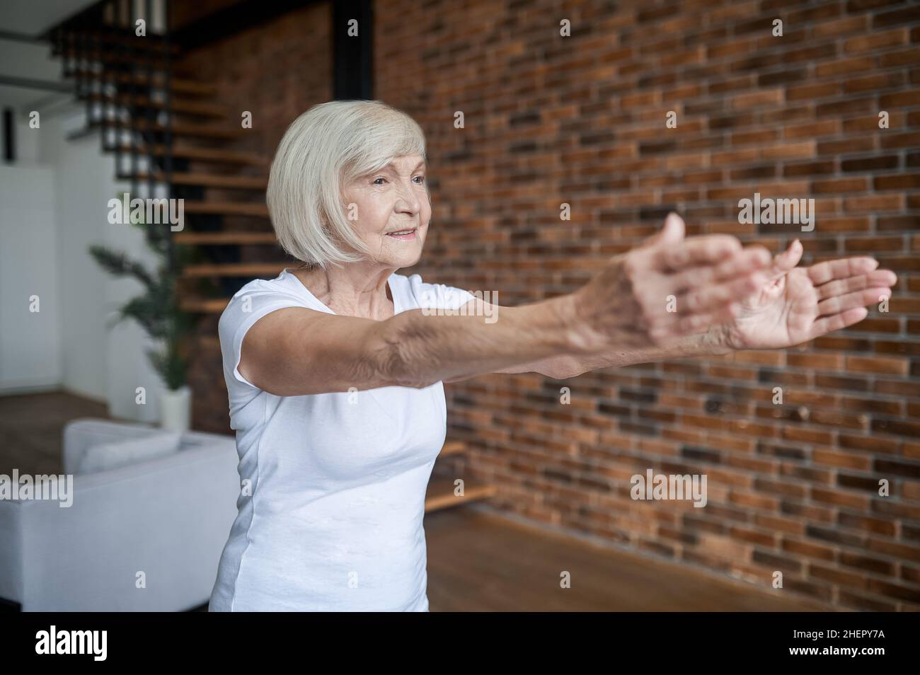 Gray-haired senior woman standing with her arms forward Stock Photo - Alamy