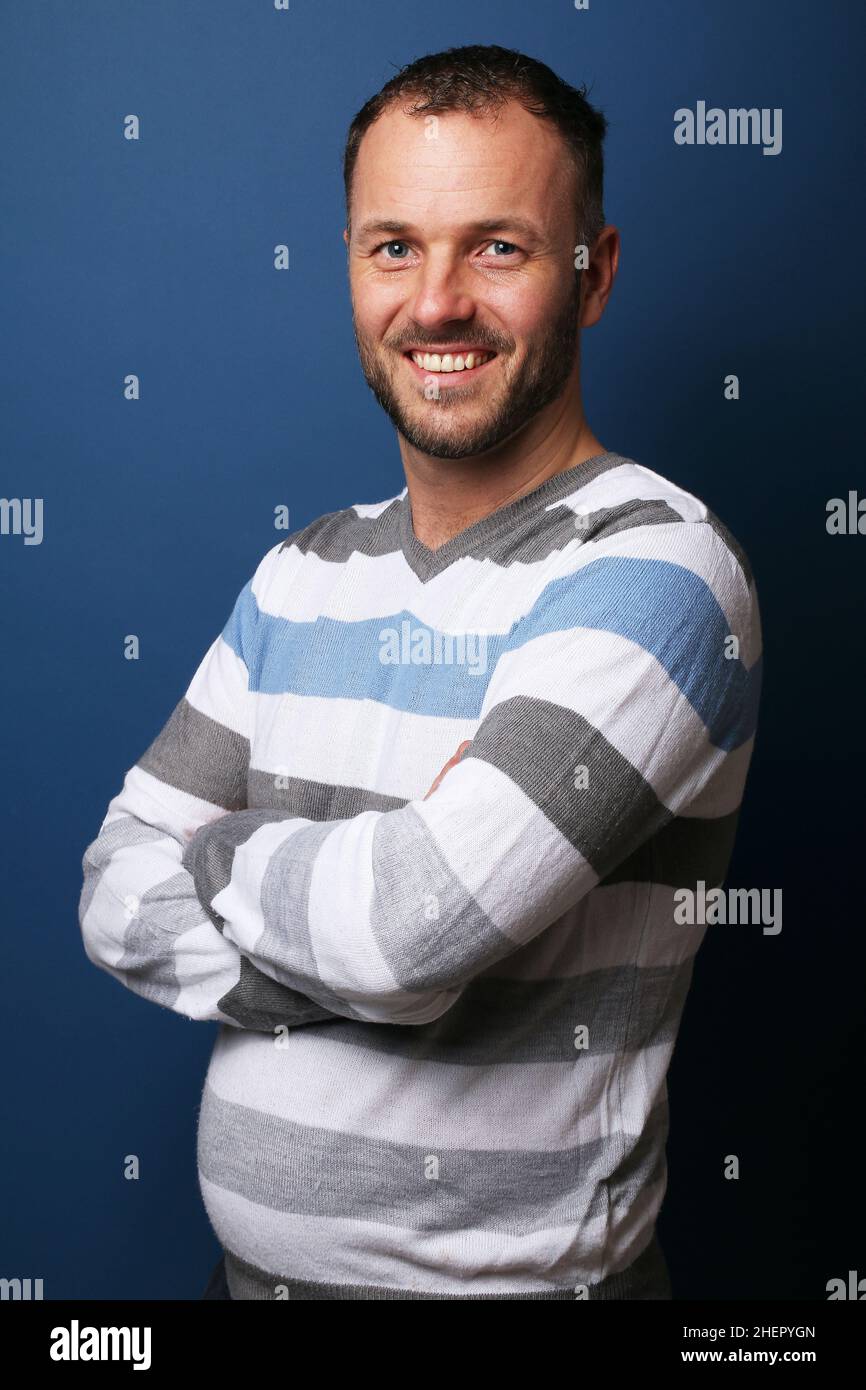 Portrait of a beautiful happy man in front of a colored background ...