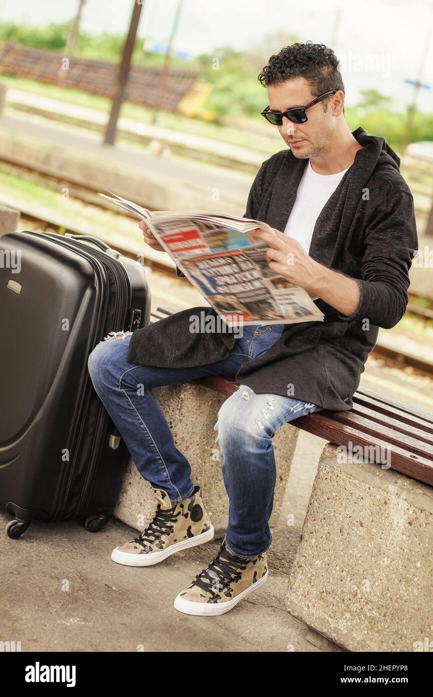 Handsome Man reading newspaper at railway station platform Stock Photo ...