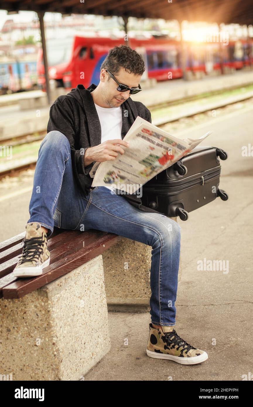 Handsome Man reading newspaper at railway station platform Stock Photo ...