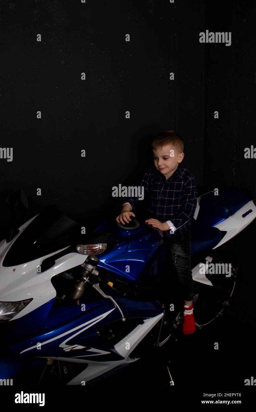 pretty charming little boy on motorcycle on black background. little ...