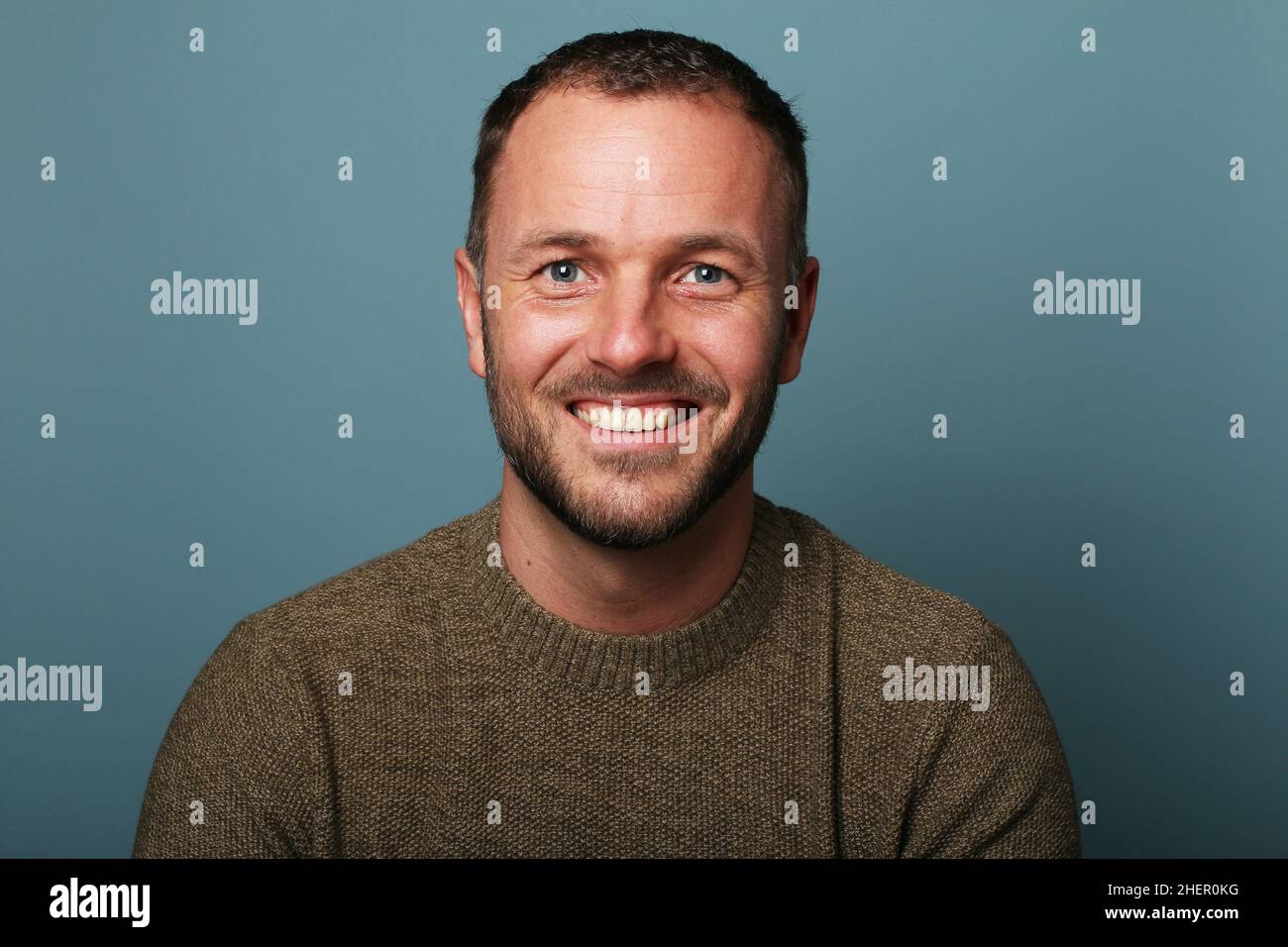 Portrait of a beautiful happy man in front of a colored background ...