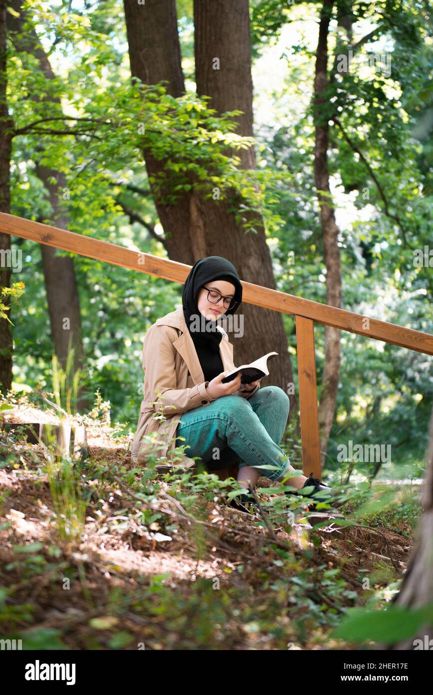 Lovely Muslim woman reading a poetry ion a beautiful spring day Stock ...