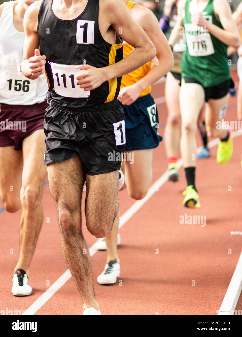 High school boys sweating while running the mile race on an indoor ...