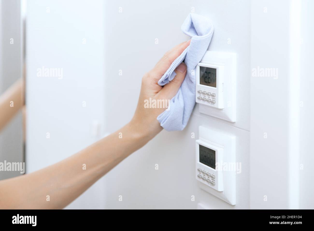 Cleaning switches and sockets with a microfiber cloth. Woman hand using ...