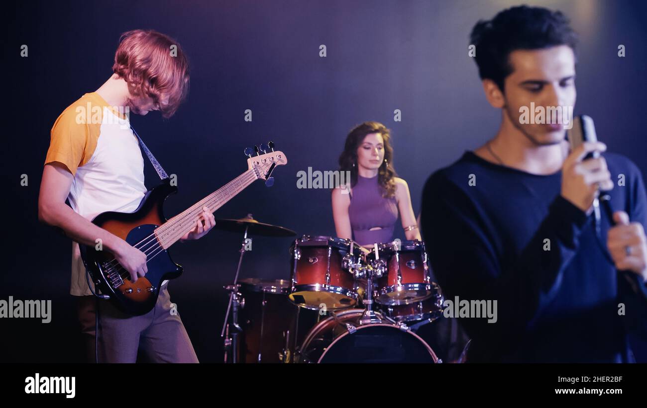 blurred young singer performing song with music band on stage,stock ...