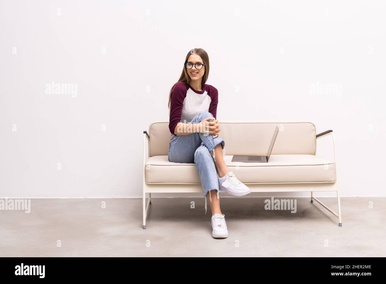 Pretty young woman happy positive smile sit couch look browse laptop ...