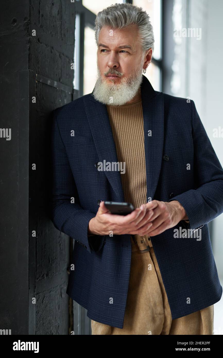 Attractive grey haired middle aged man in business casual wear looking ...