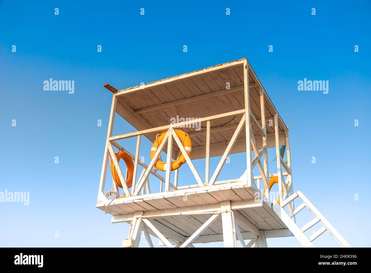 Empty lifeguard house with a bright yellow lifeline on a sunny summer ...