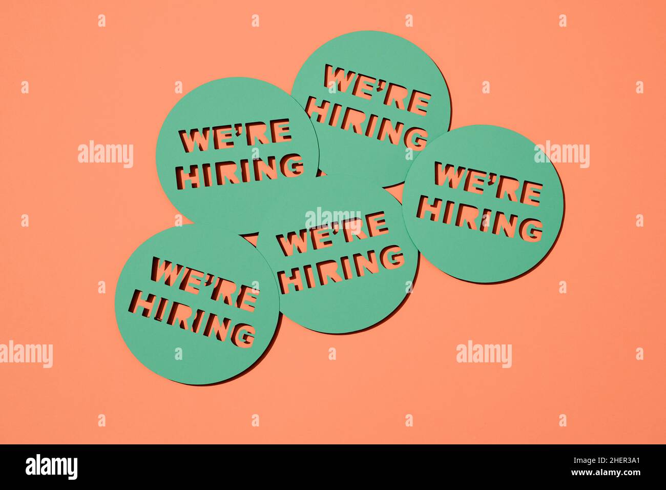 some round-shaped green pieces of paper with the text we are hiring cut ...