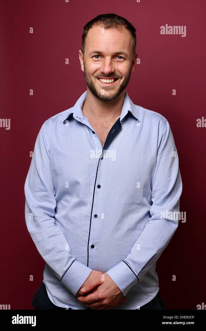 Portrait of a beautiful happy man in front of a colored background ...