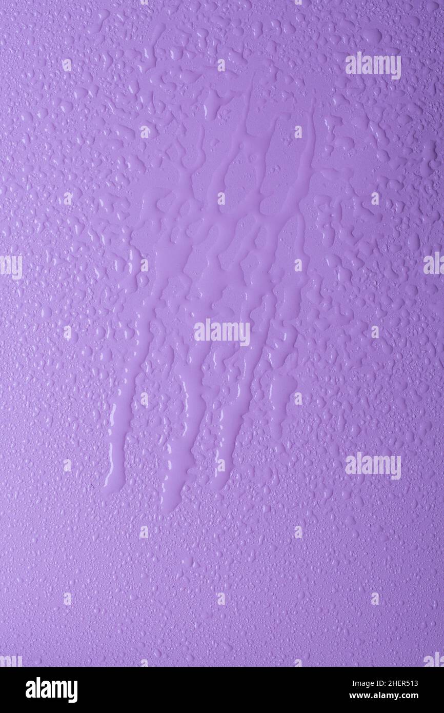 Water drops on purple color surface Stock Photo - Alamy