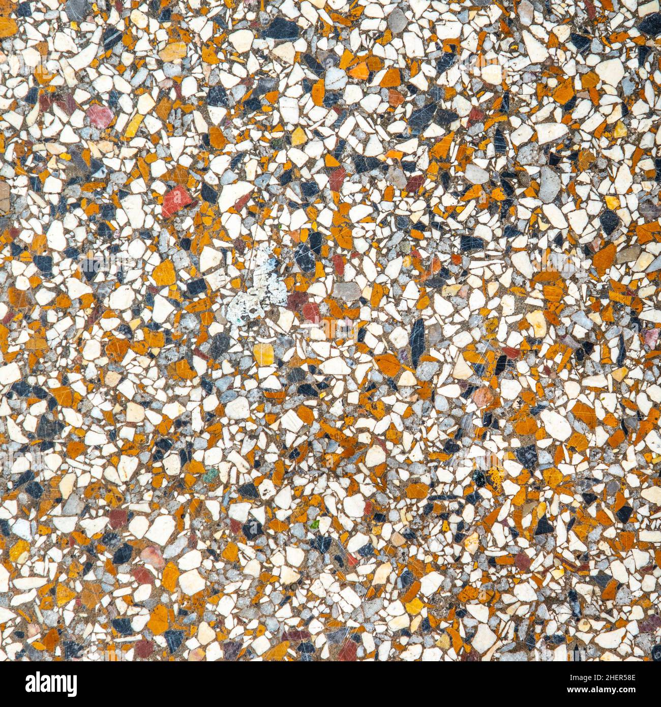 old concrete floor with small pieces of marble and natural stones as ...