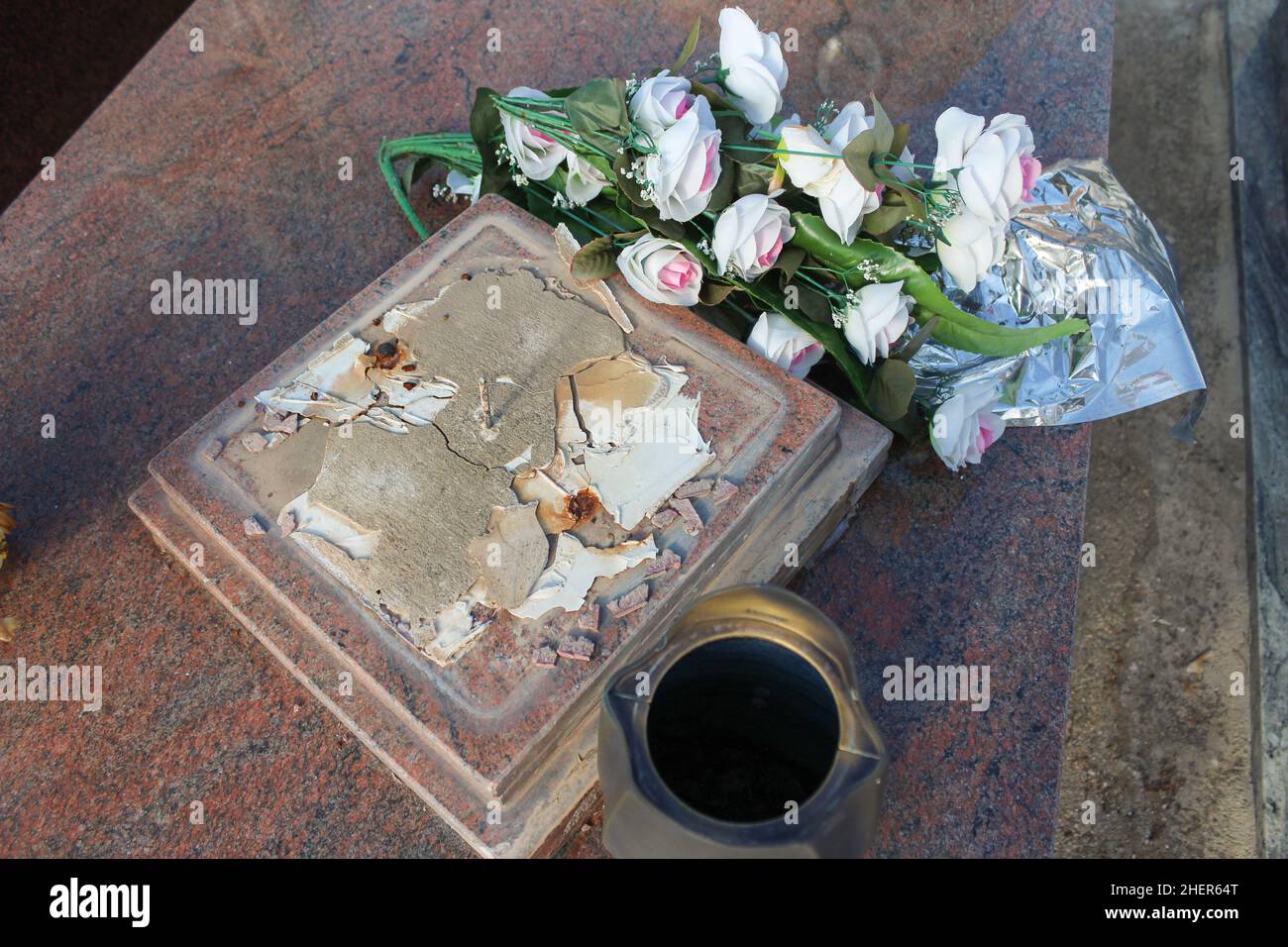 A broken gravestone made of granite, a desecrated grave, a profanation ...