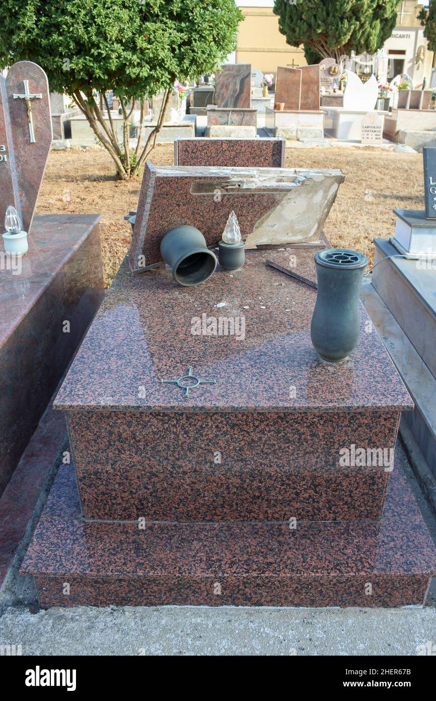 A broken gravestone made of granite, a desecrated grave, a profanation ...