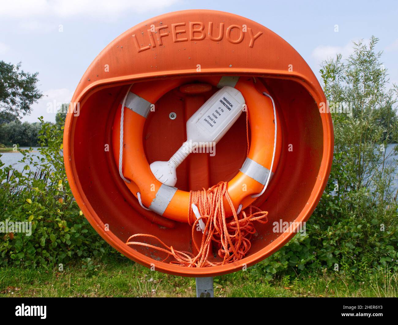 A weathered lifebuoy in its orange housing cabinet in front of a ...