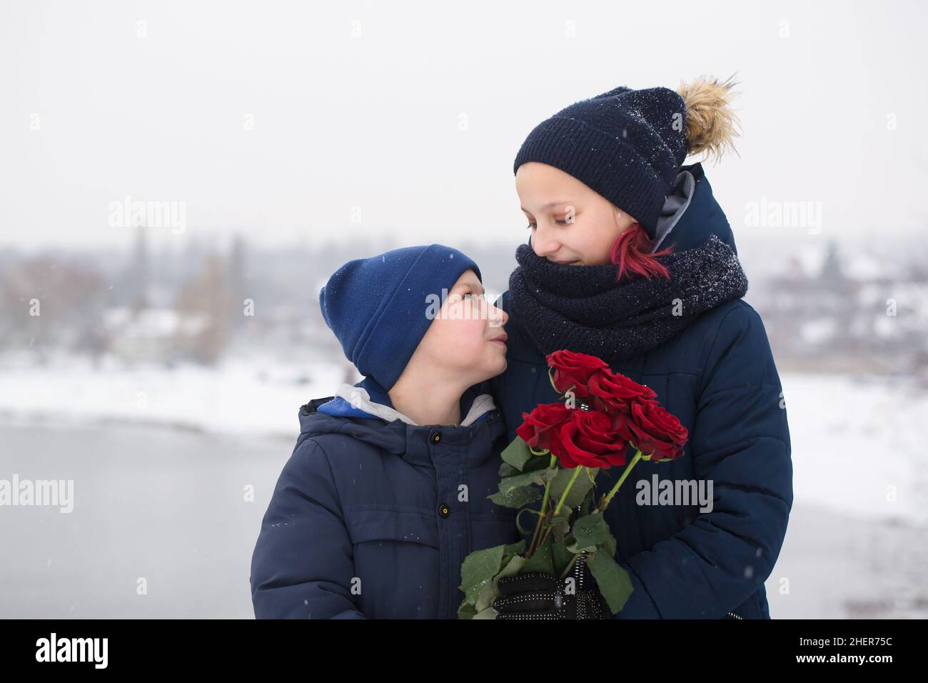 The boy gives the girl red roses Stock Photo - Alamy