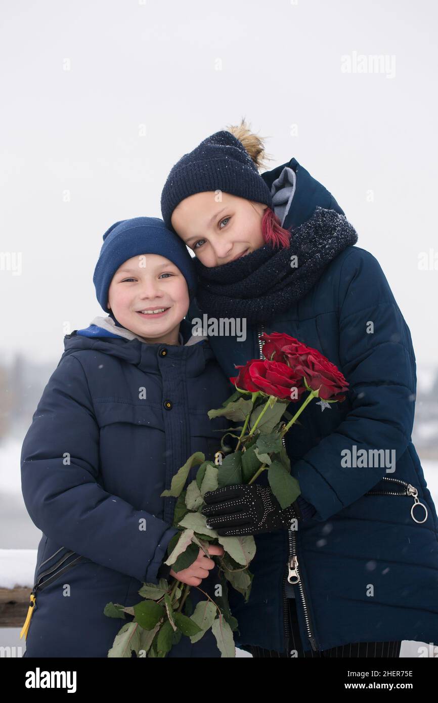 The boy gives the girl red roses Stock Photo - Alamy