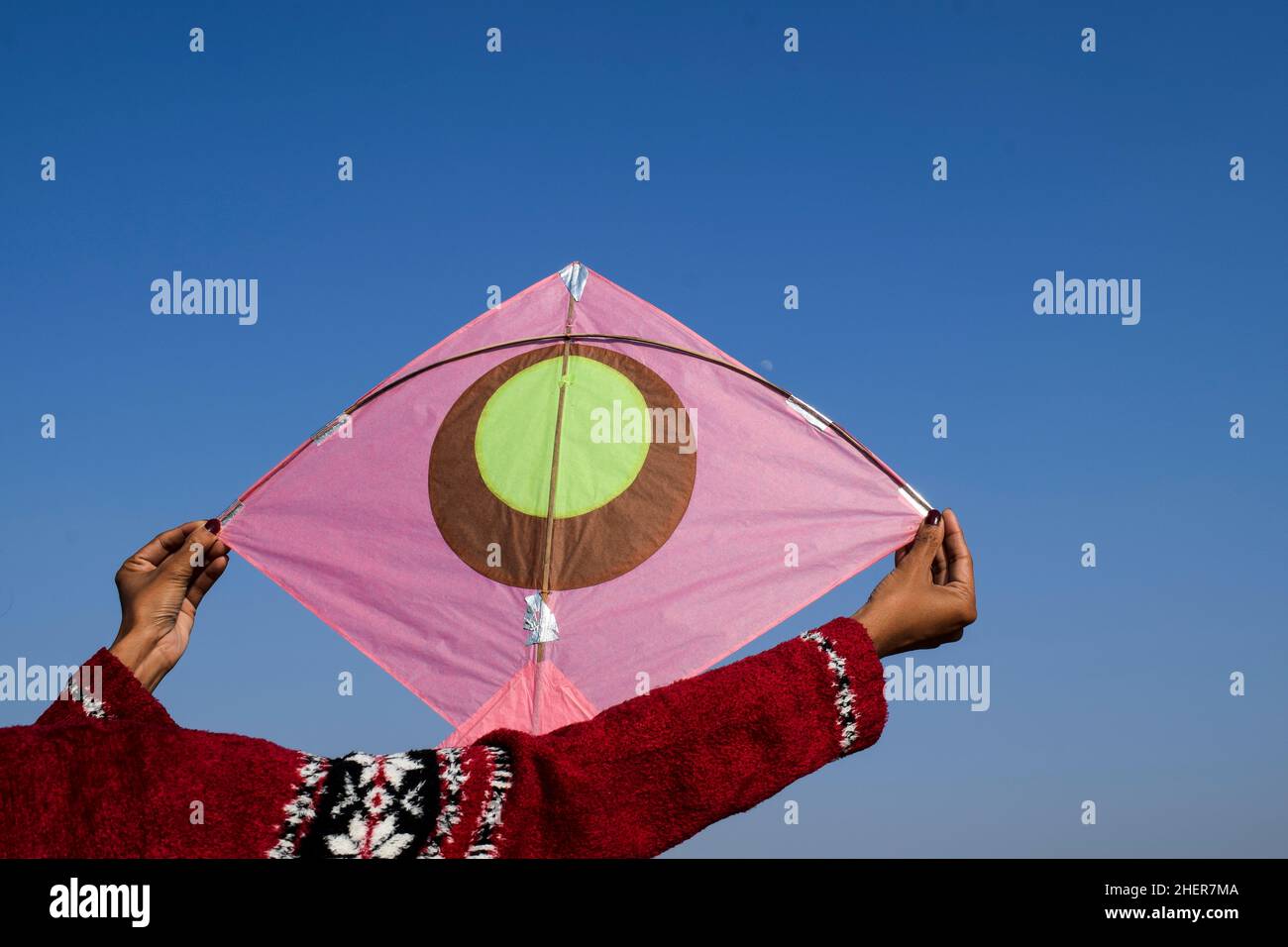 Female holding and flying kite with sky background on occasion of ...