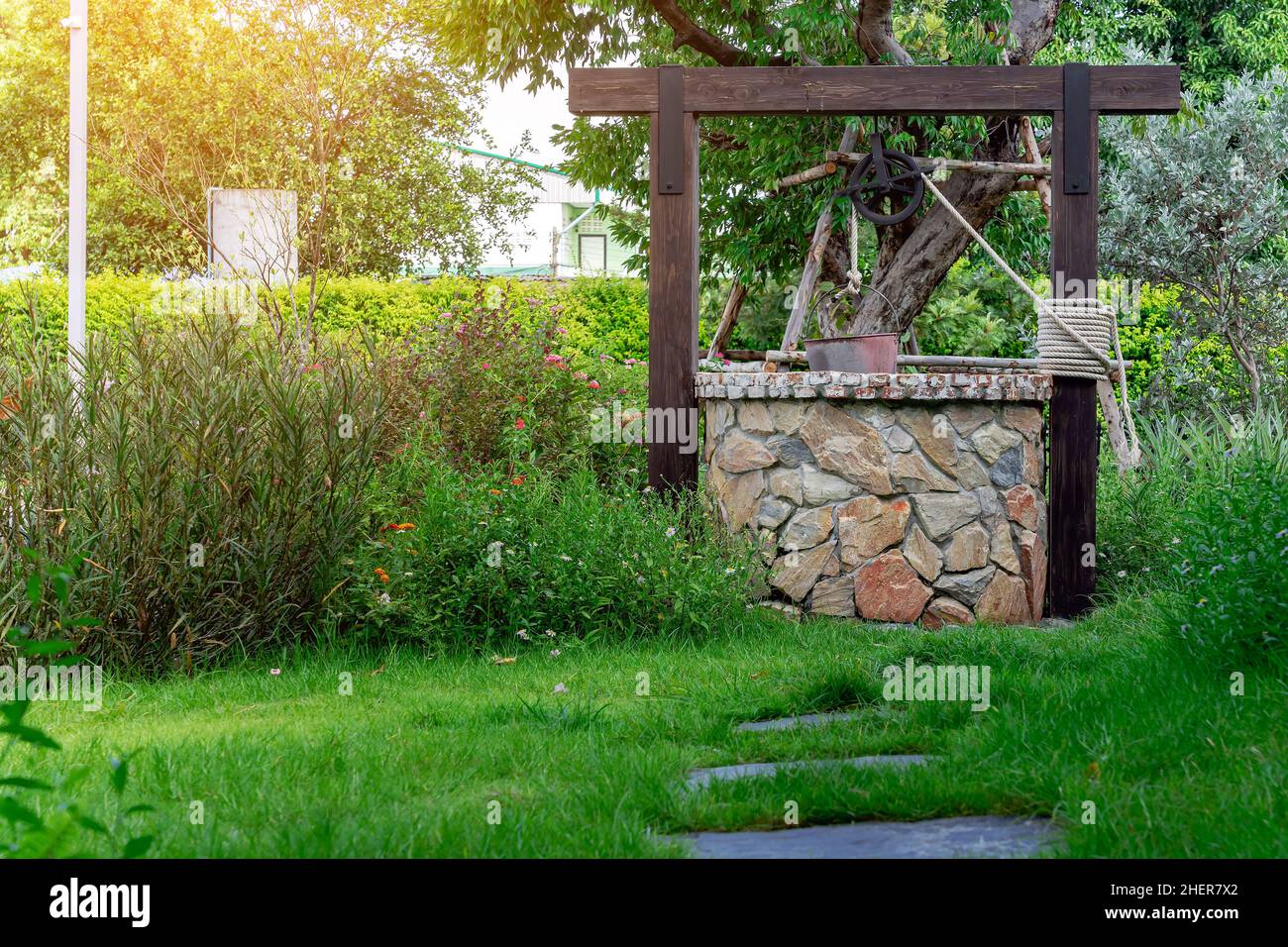 Beautiful artesian well made by stones and wheel pulley with metal ...
