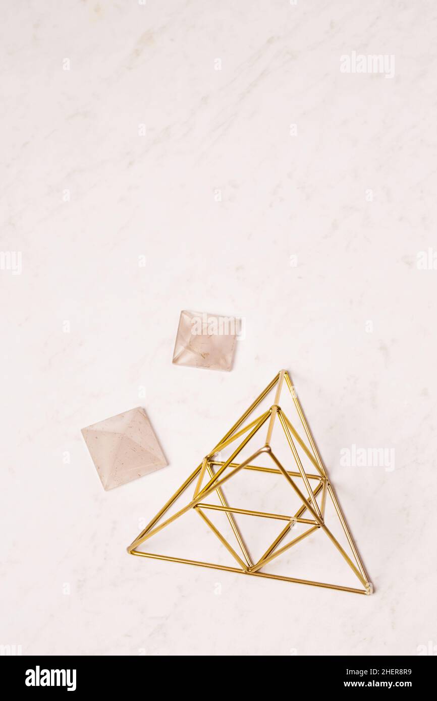 golden pyramid of wishes and rock crystal pyramids on a white ...