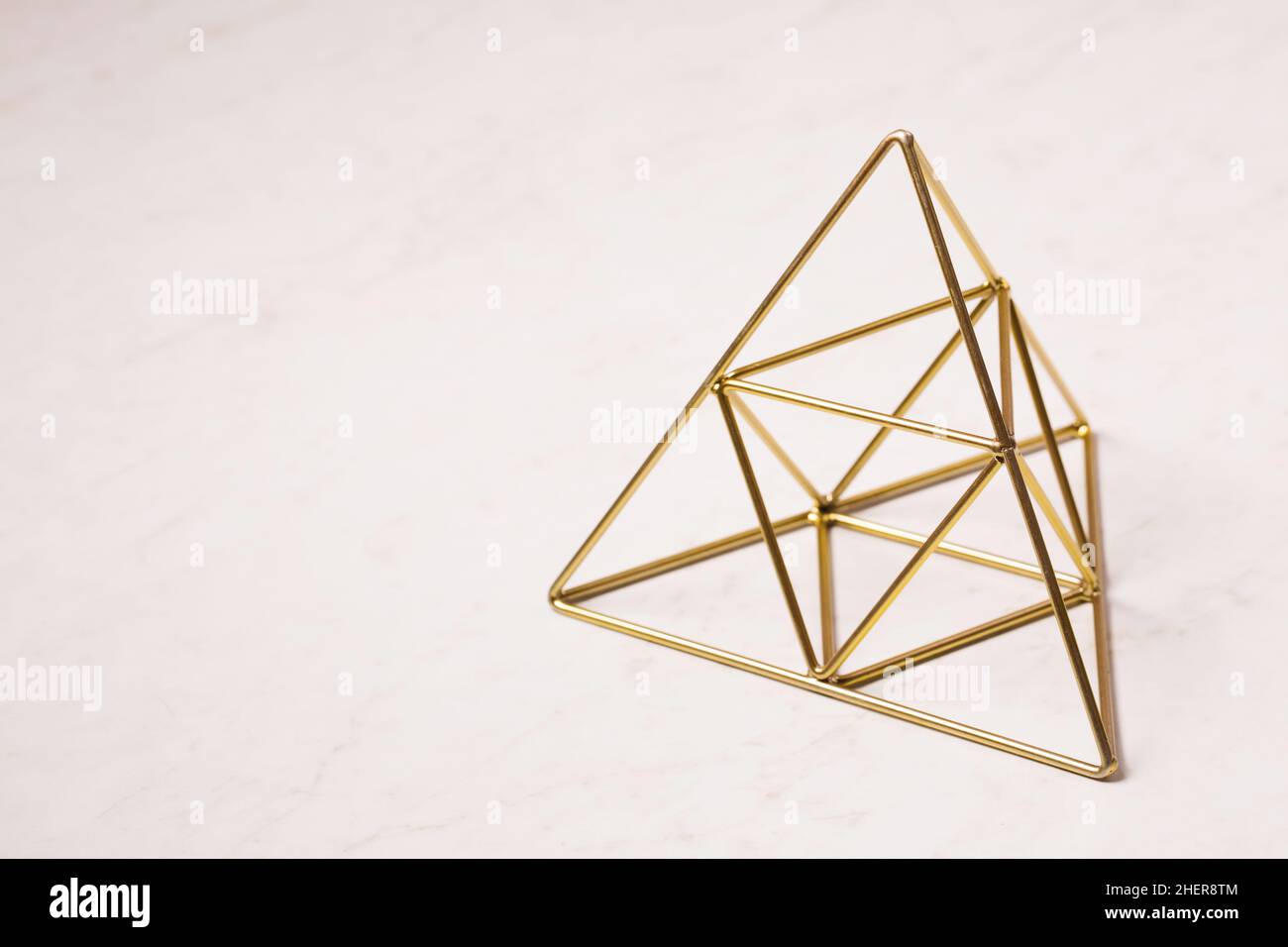 golden pyramid of wishes on a white background Stock Photo - Alamy