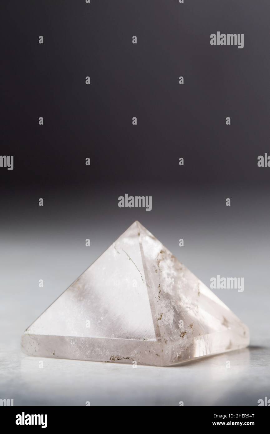 Natural rock crystal pyramid against a dark background, Reiki concept ...