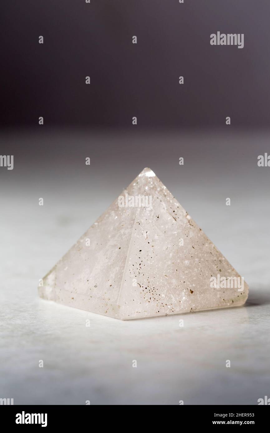 Natural rock crystal pyramid against a dark background, Reiki concept ...