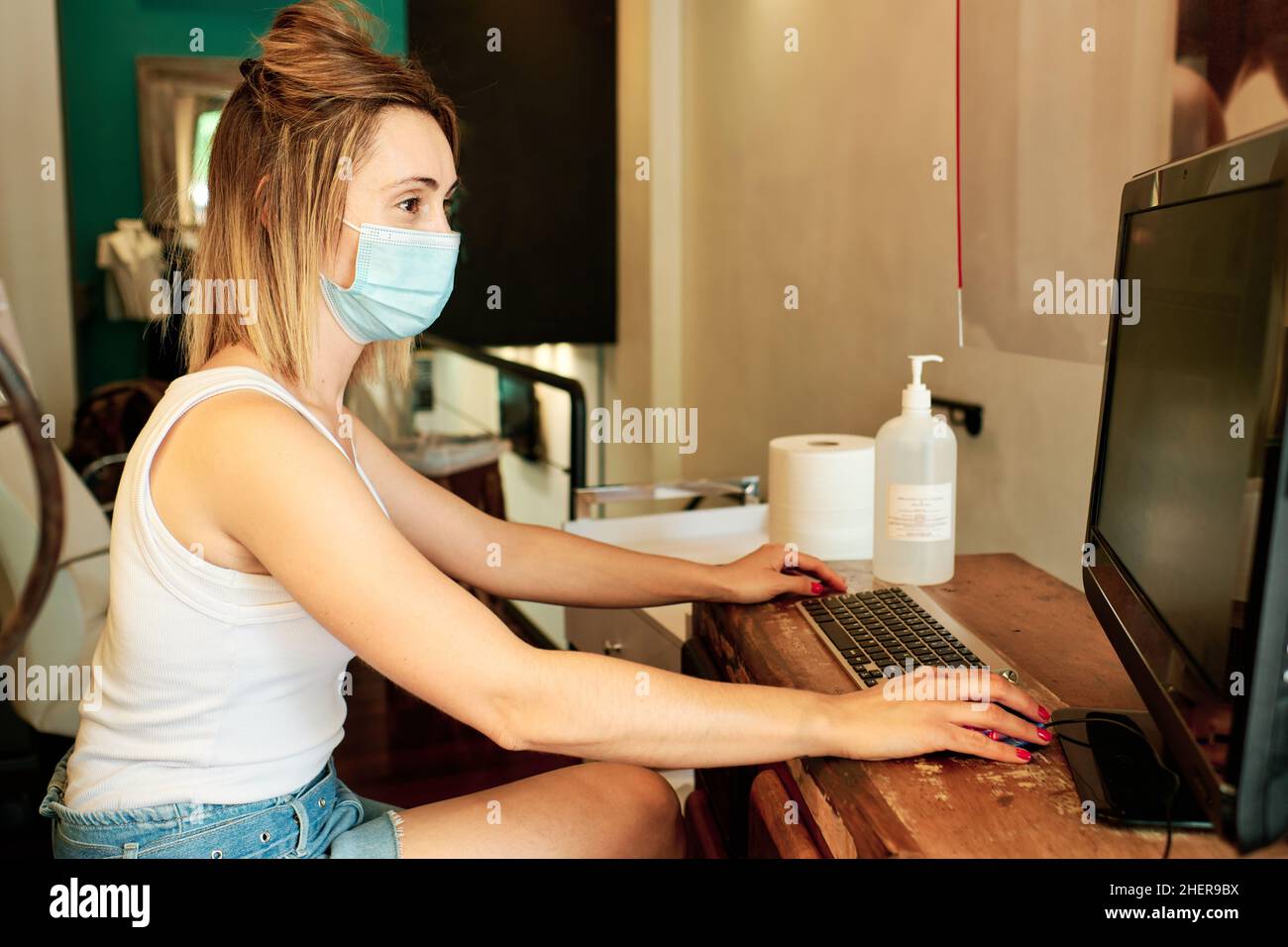 cashier with a face mask using the computer during the coronavirus ...