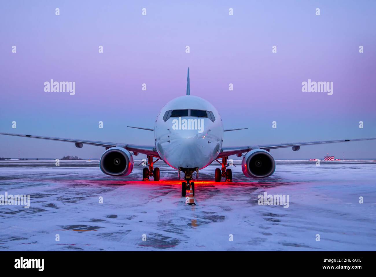 Front view of a white passenger jet plane on an airport apron in cold ...