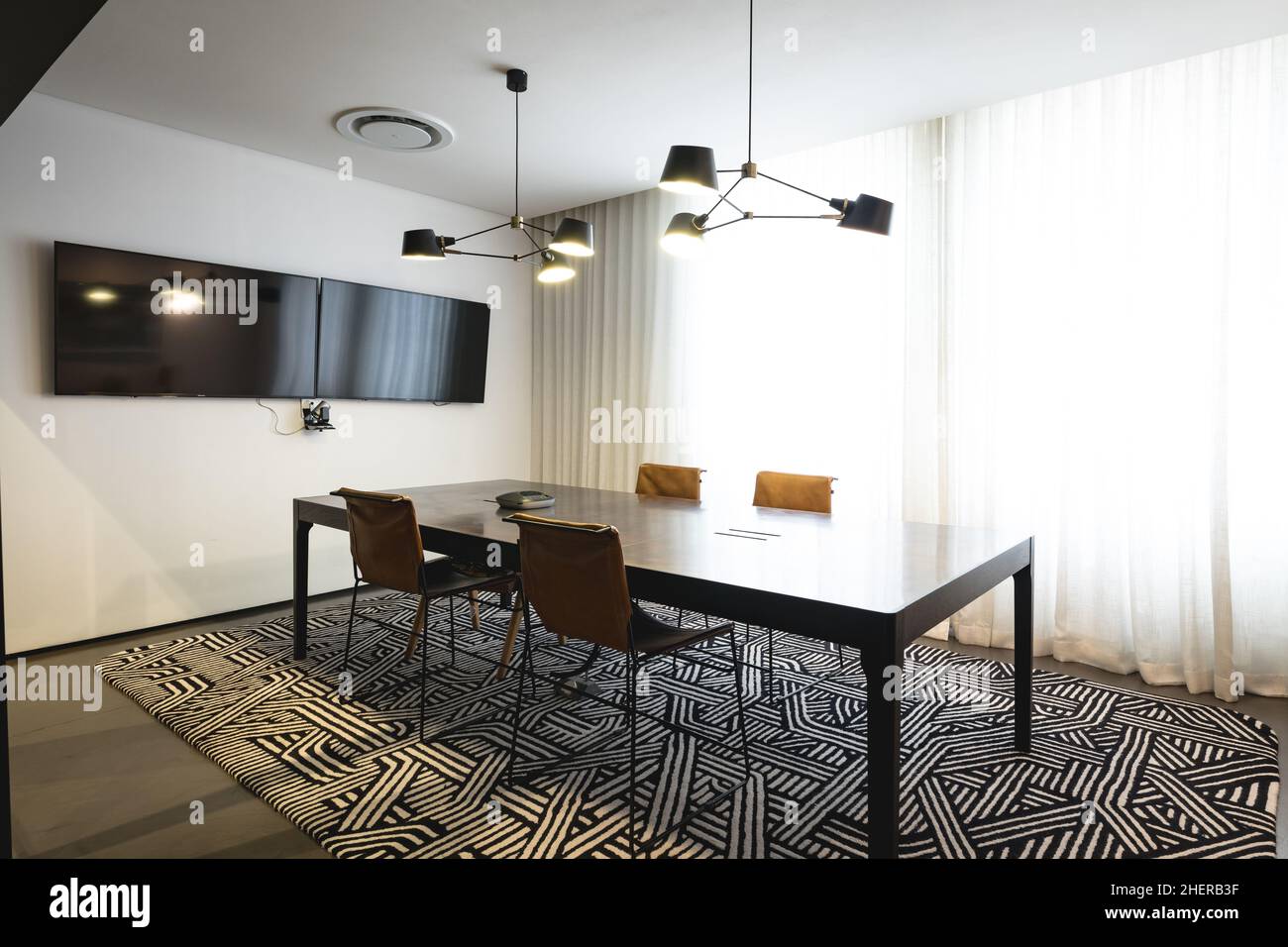 Interior of illuminated modern board room with conference table and ...