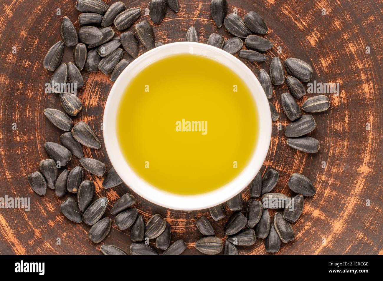 Many delicious sunflower seeds with a saucer of sunflower oil on a clay ...