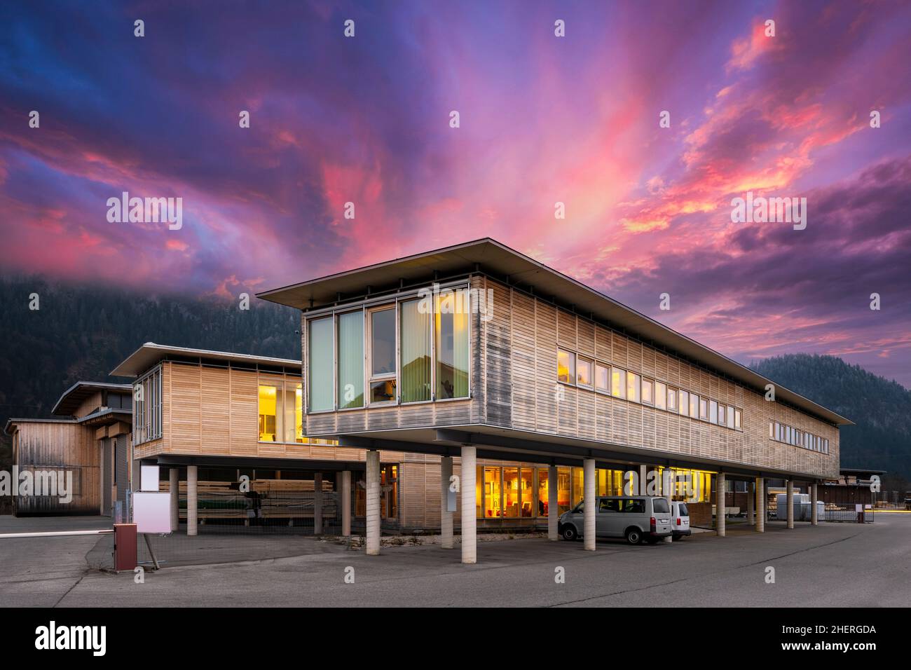 Sustainable wood office building on pillars with parking spaces ...