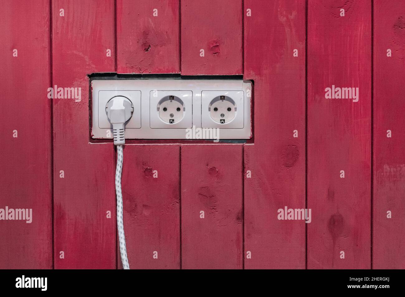 Connect the power and energy plug cable to the outlet on the red wooden ...