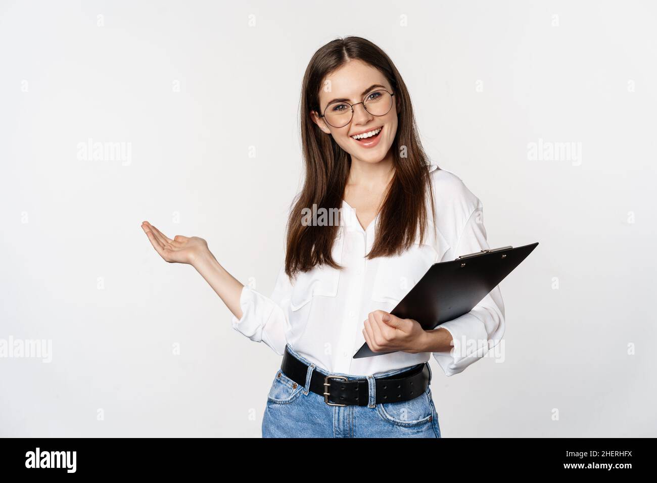 Smiling brunette woman, office lady showing way, pointing behind ...