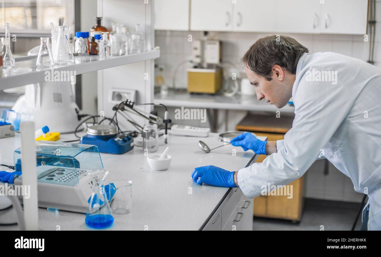 Male laboratory researcher performs tests in the medical or scientific ...