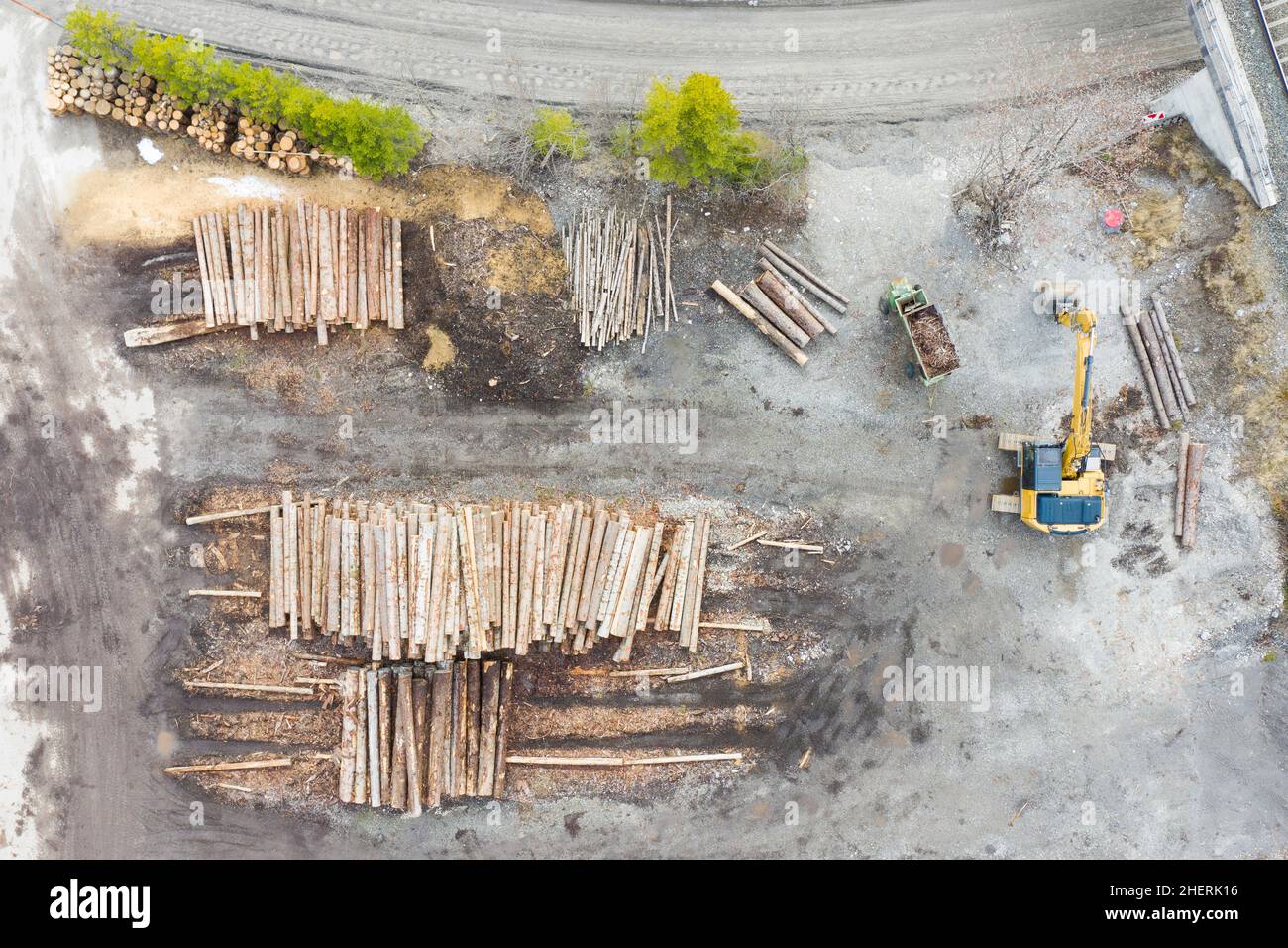 top birds eye view to stack of timber wood of sawmill with digger at ...