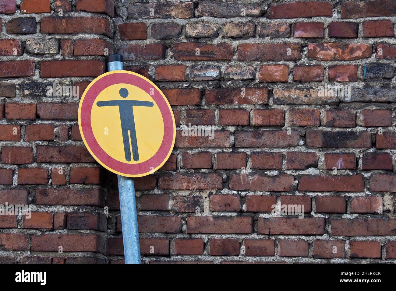 Round traffic sign with man gesturing with outstretched arms in front ...