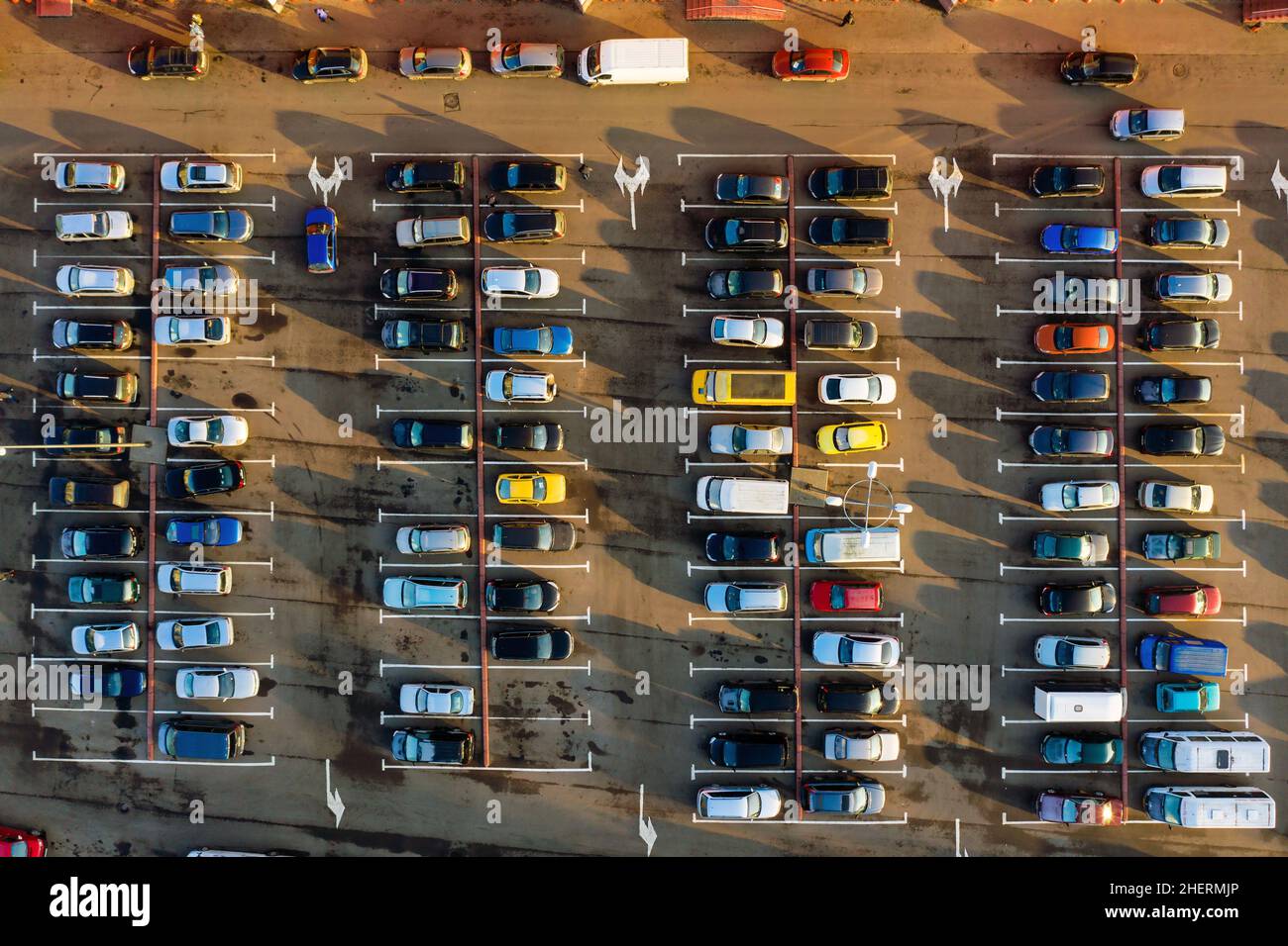 Aerial of a parking lot near supermarket. Colorful cars parked near ...
