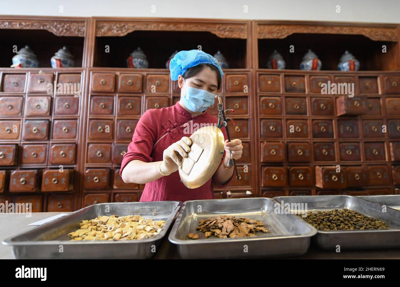 Tianjin. 12th Jan, 2022. A pharmacist weighs ingredients to produce ...