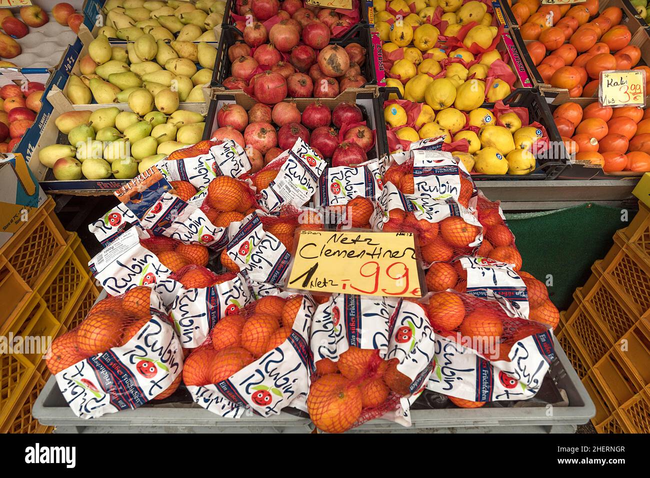 Clementines in a net and different fruit varieties at a market stall ...