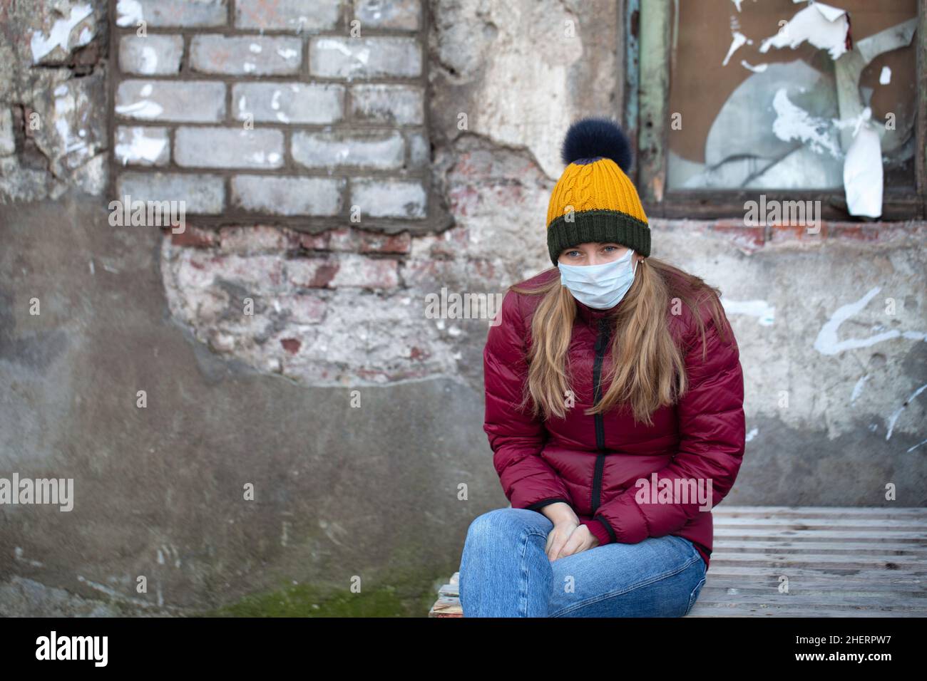 Shivering cold woman wearing a medical face mask to stop spreading flu ...