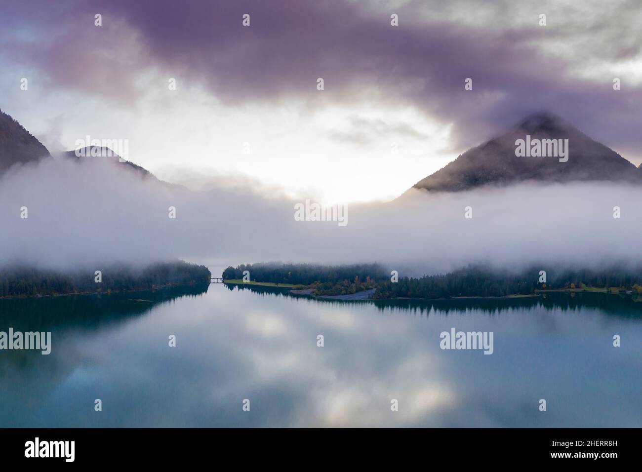 channel with bridge at dawn mood with foggy clouds at heiterwang ...