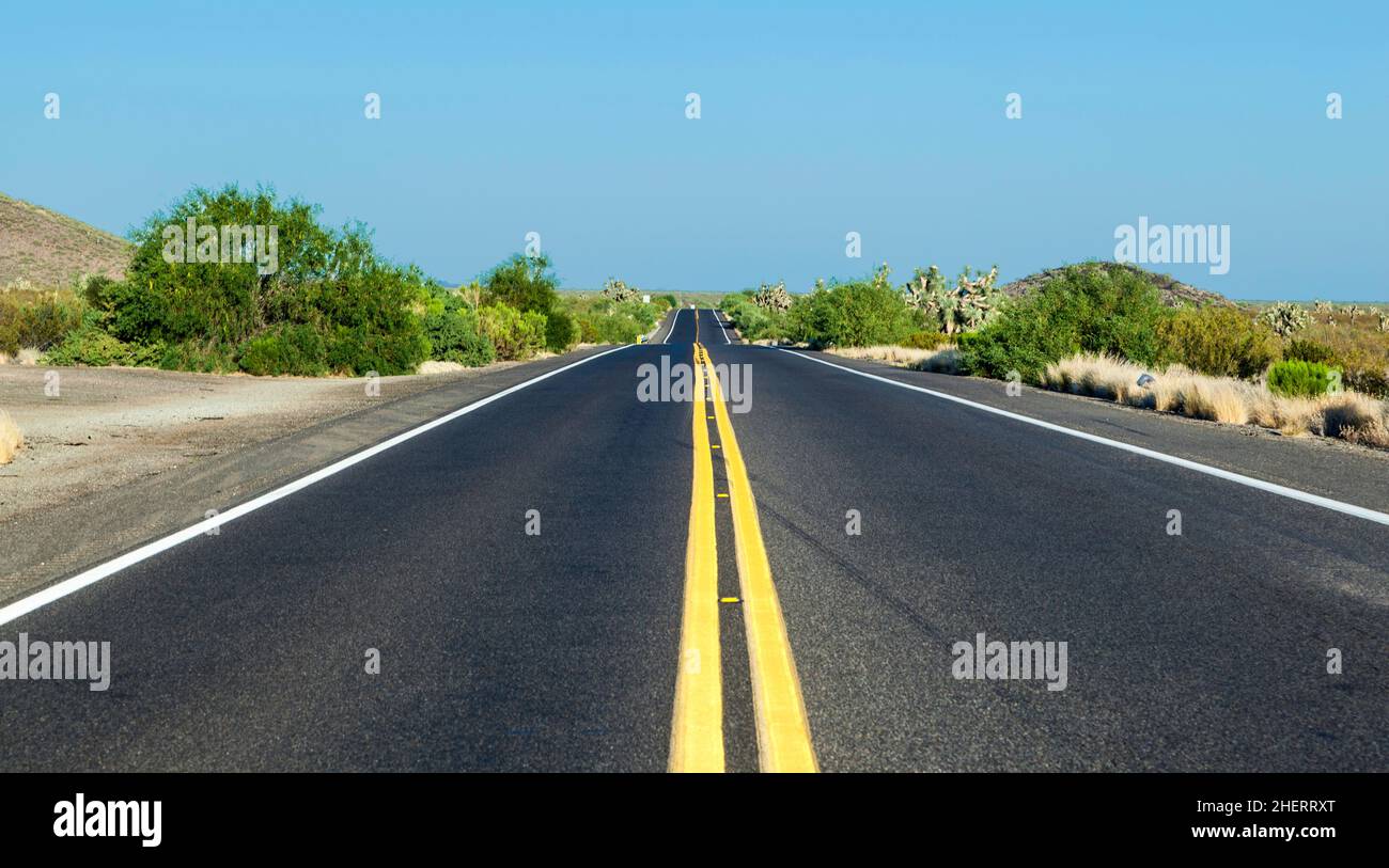 empty freeway in sunset with yellow lines to indicate overtaking ...