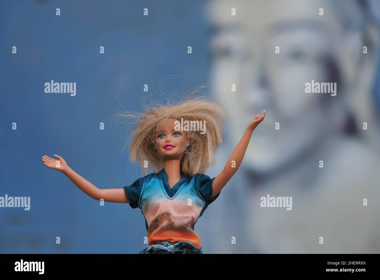 Barbie doll with the gesture of outstretched arms in front of wall with ...