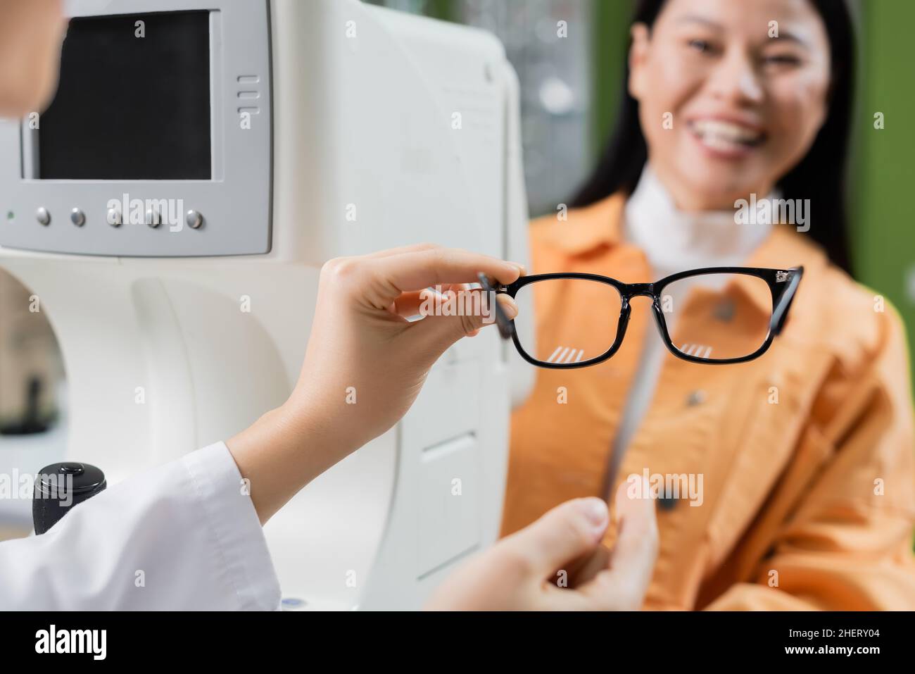 selective focus of eyeglasses in hand on oculist near vision screener ...
