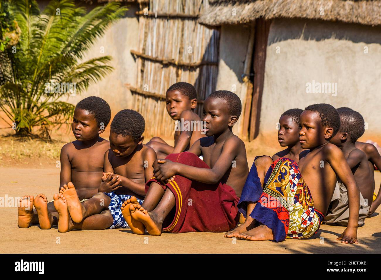 Children watch with interest at traditional customs in real African ...