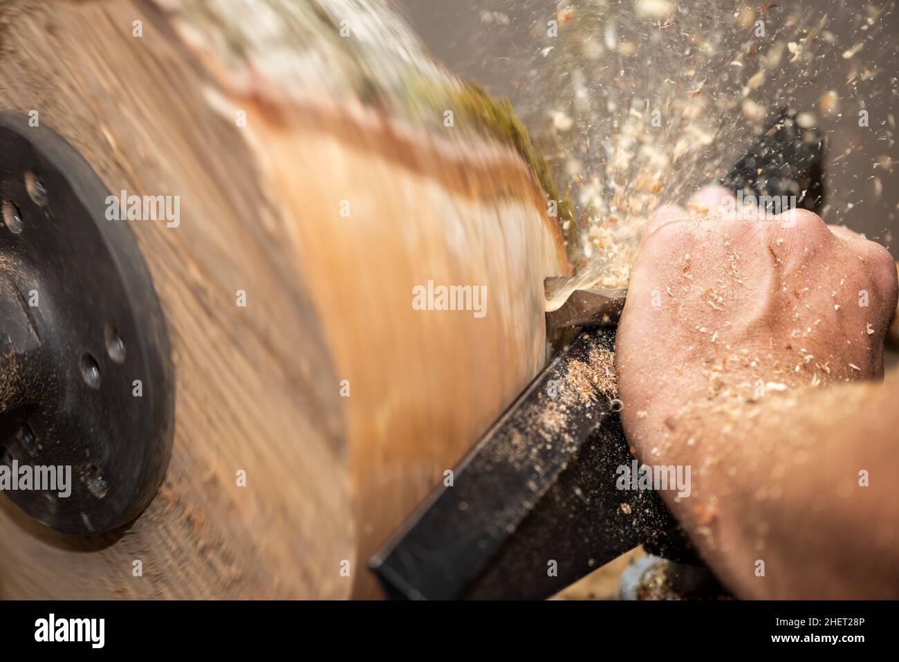 hand of man cuts piece of timber with flying sawdust and shavings Stock ...