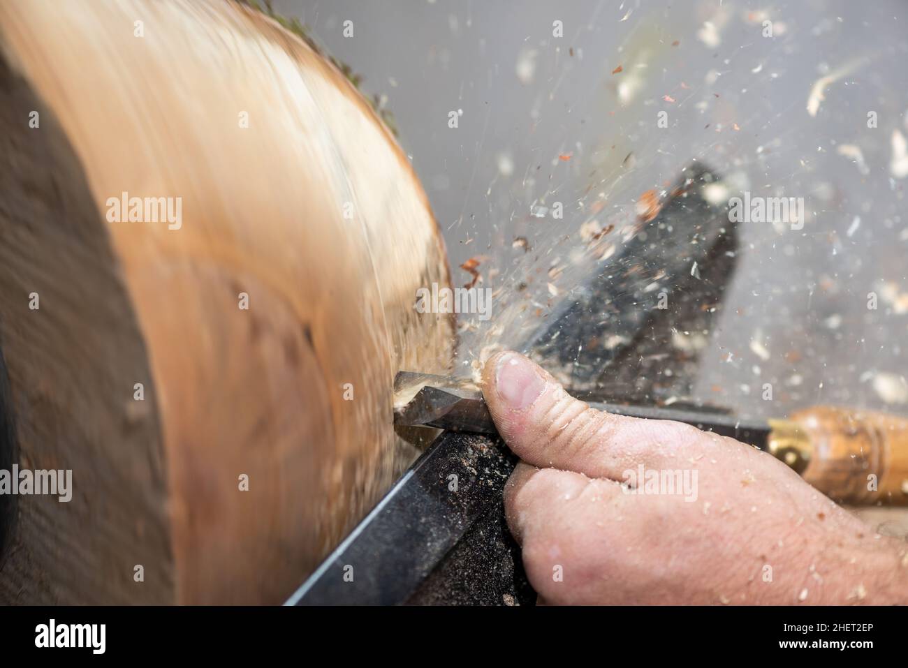 mortise chisel with sawdust on rotating piece of wood while forming a ...